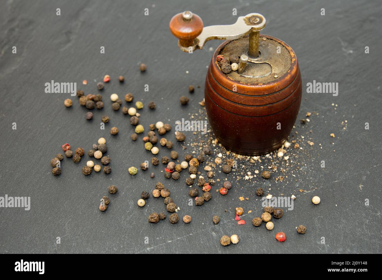 old pepper grinder and assorted pepper whole grains and ground pepper ...