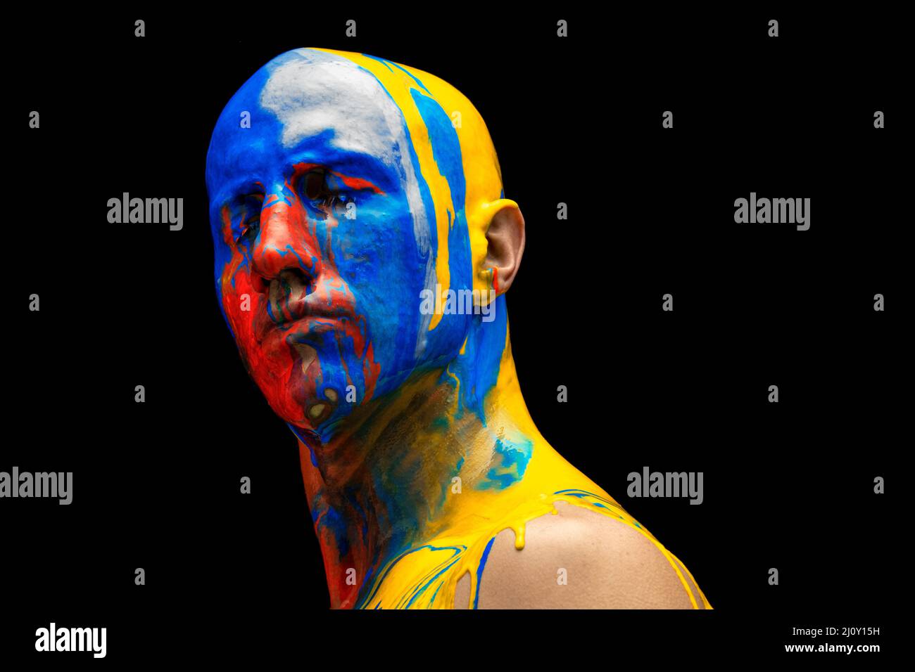Conceptual image. Male head covered with blue, white, red and yellow ...