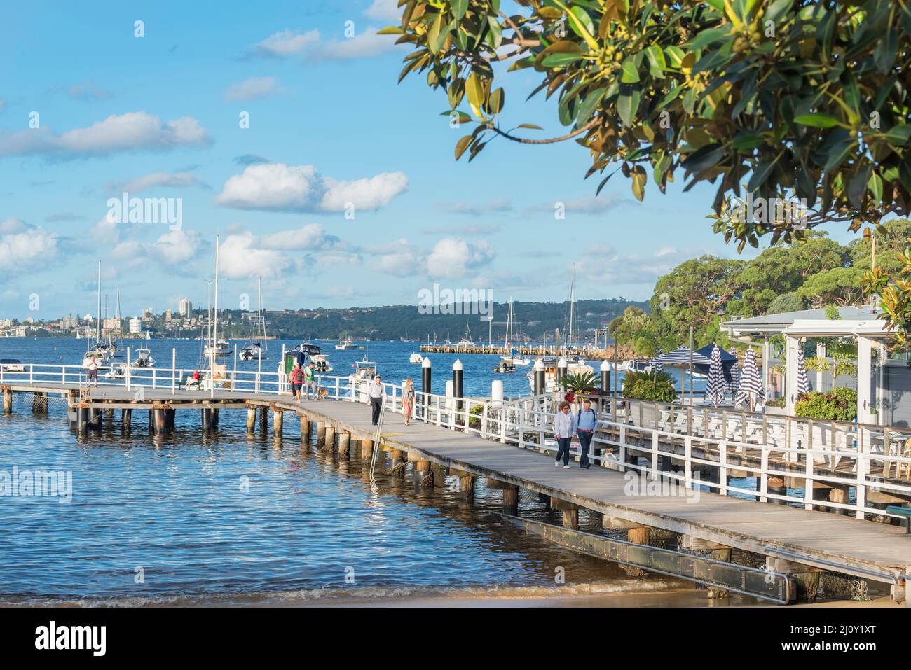 People walk around the jetty or pier that surrounds the netted swimming ...