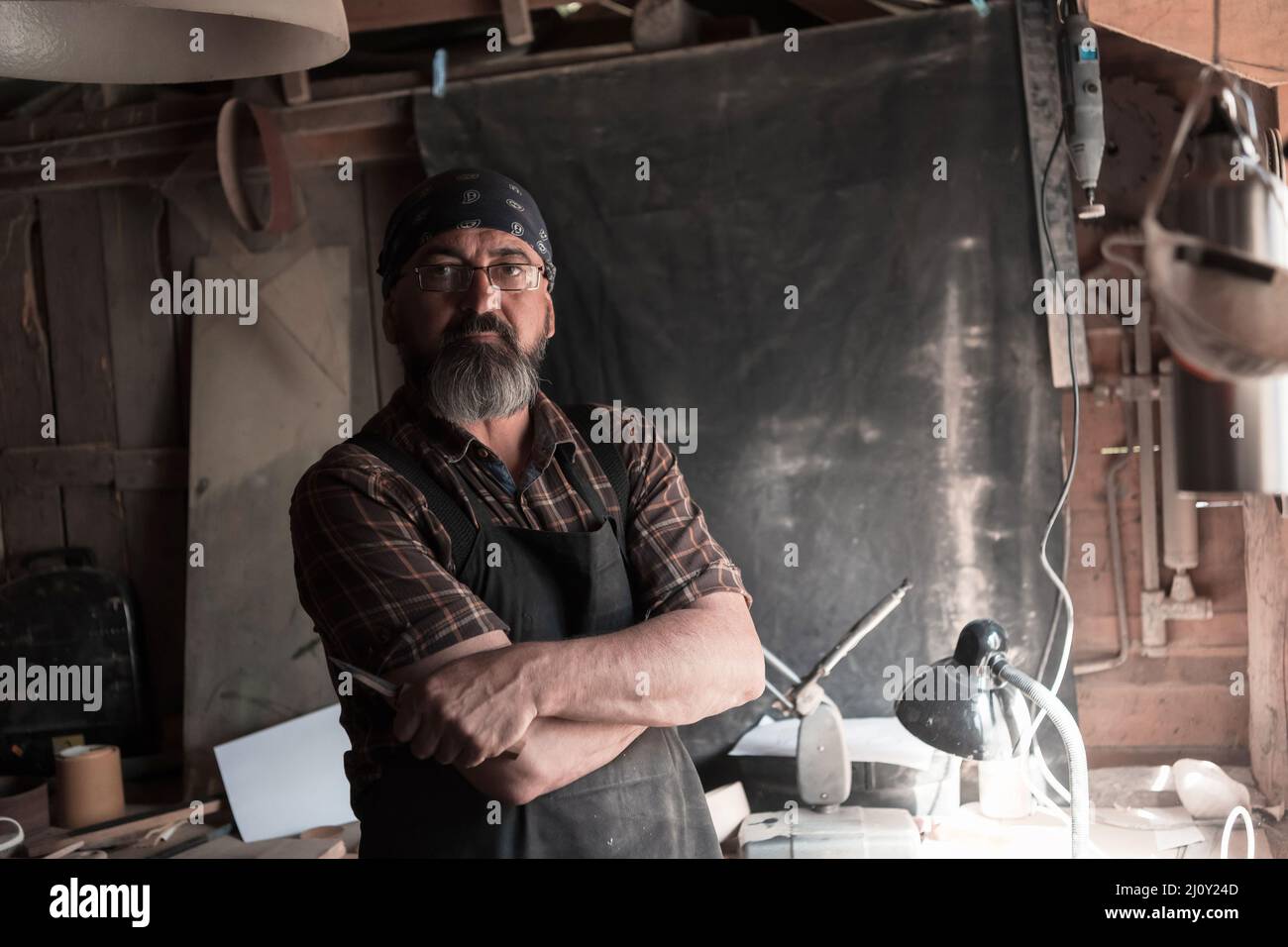 Spoon craft master in his workshop with handmade wooden products and ...