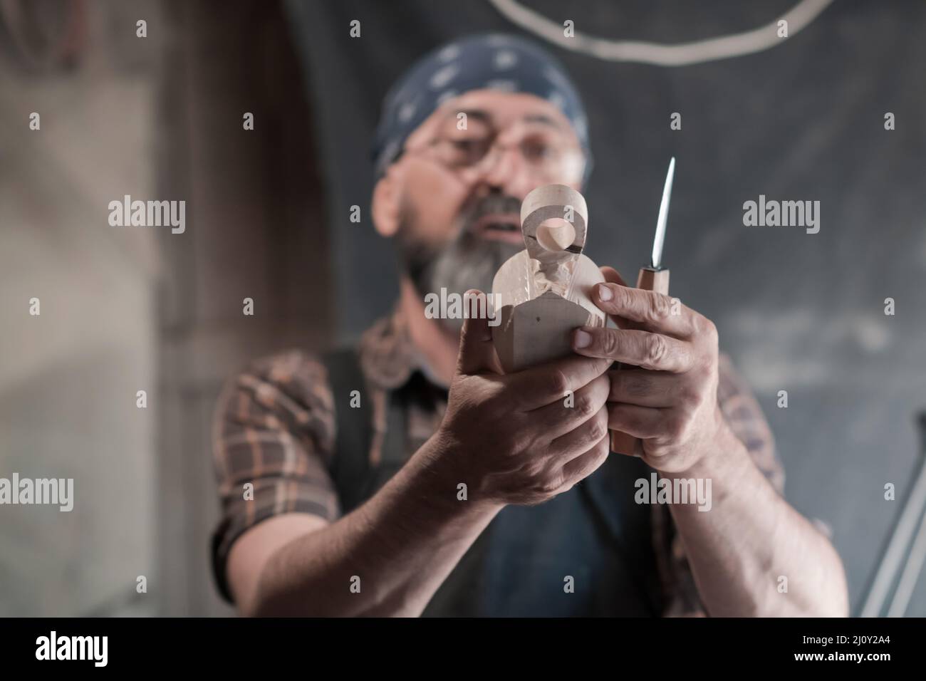 Spoon craft master in his workshop with handmade wooden products and ...