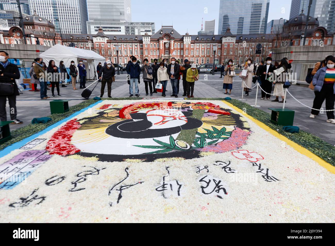 Tokyo, Japan. 21st Mar, 2022. Visitors look at a huge kabuki actor ...