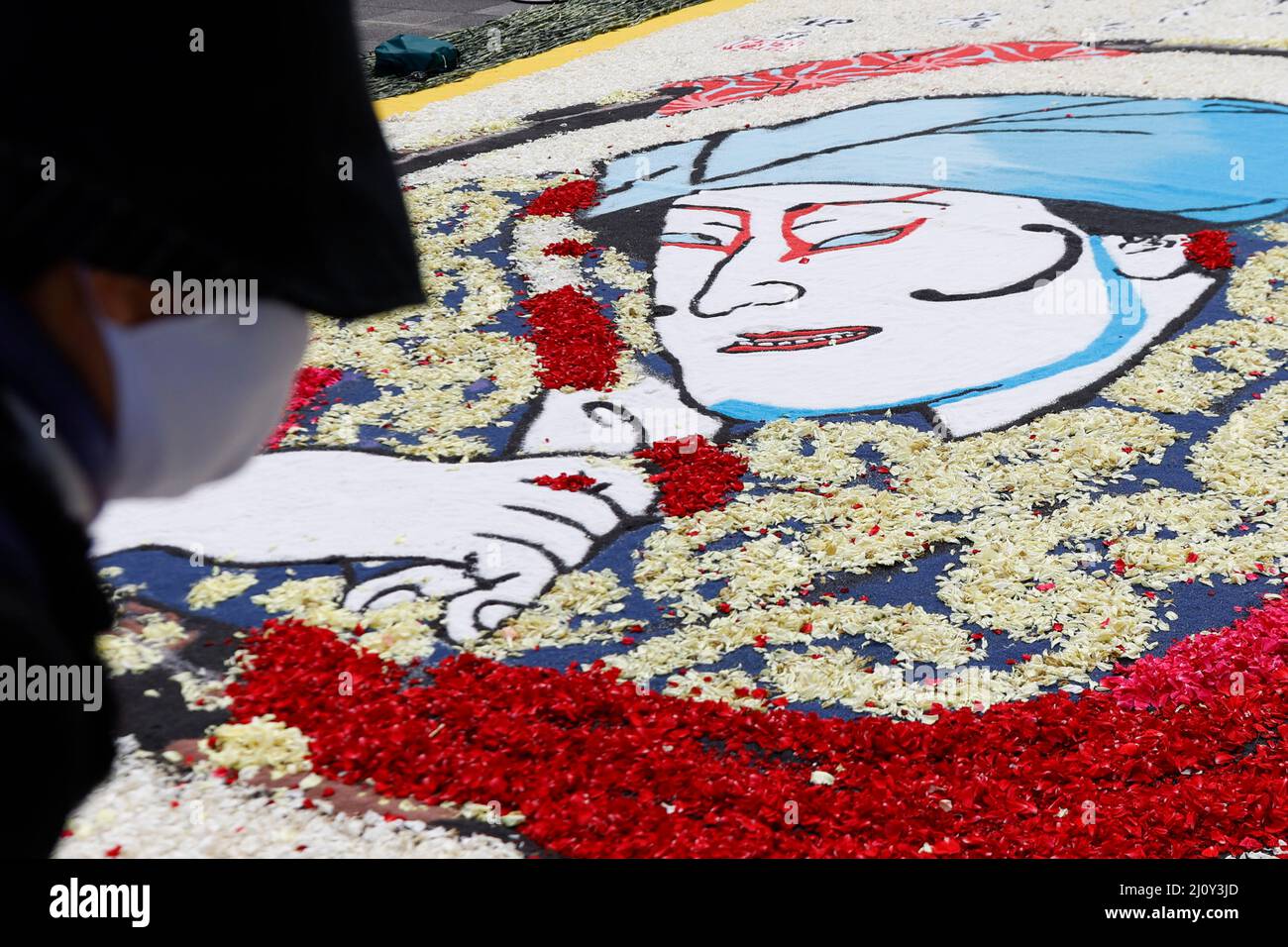 Tokyo, Japan. 21st Mar, 2022. A woman looks at a huge kabuki actor ...