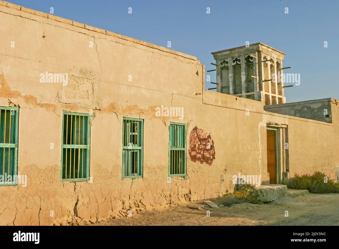 An old building and a windtower in Al Jazirat Al Hamra, an abandoned ...