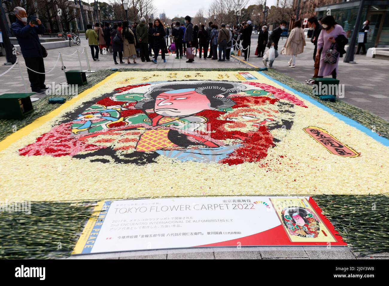 Tokyo, Japan. 21st Mar, 2022. Visitors look at a huge kabuki actor ...