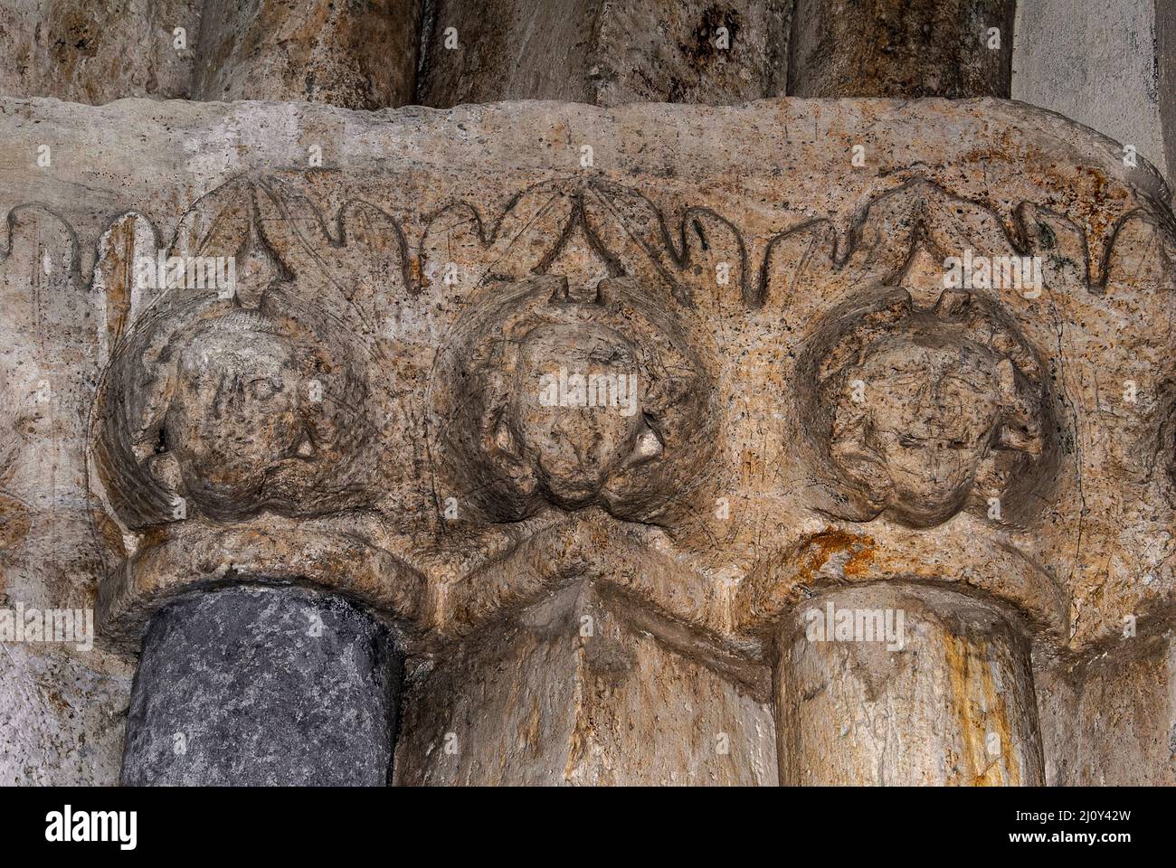 Weathered human faces surrounded by foliage sculpted in about 1320 on ...