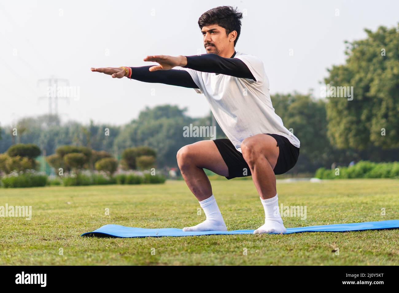 Young indian boy squatting and working out in the park - concept of ...