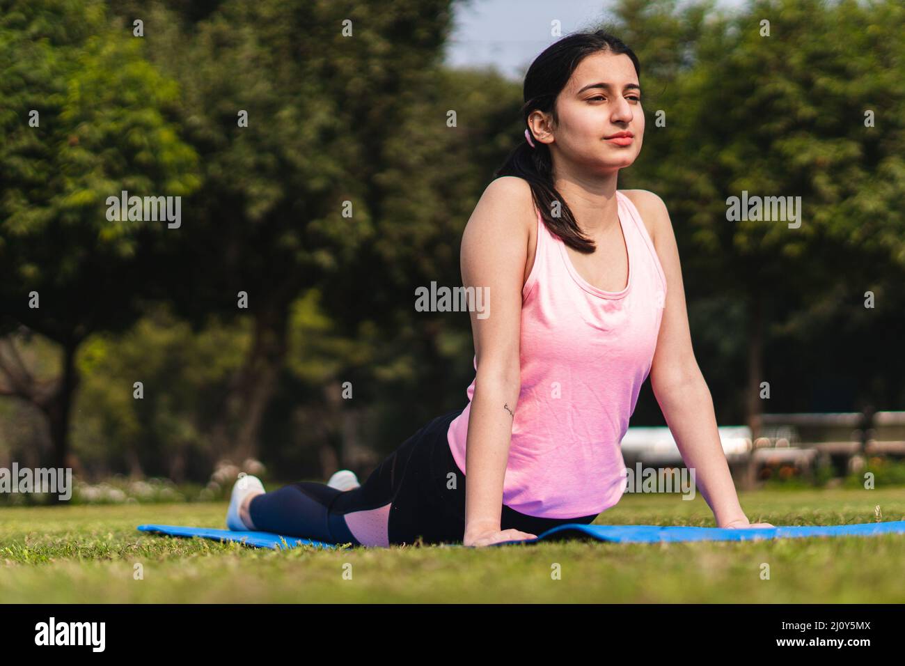 Young indian girl stretching in the park - concept of healthy lifestyle ...