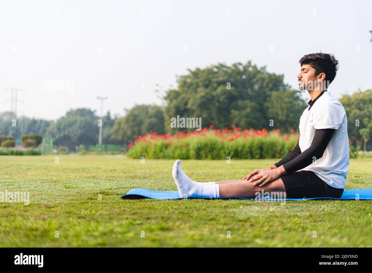 Young indian boy stretching in the park - concept of healthy lifestyle ...