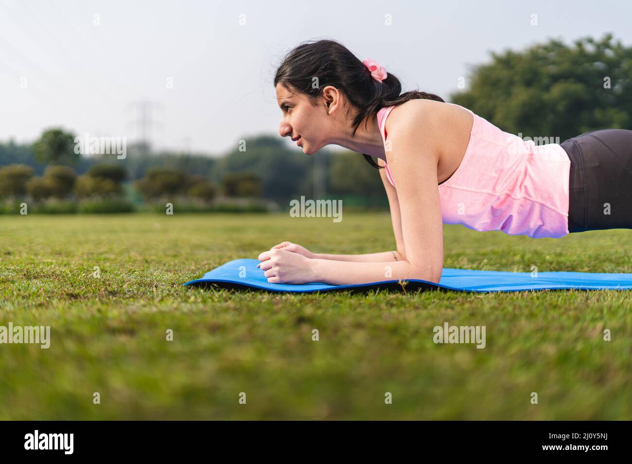 Young indian girl doing planks in the park - concept of healthy ...