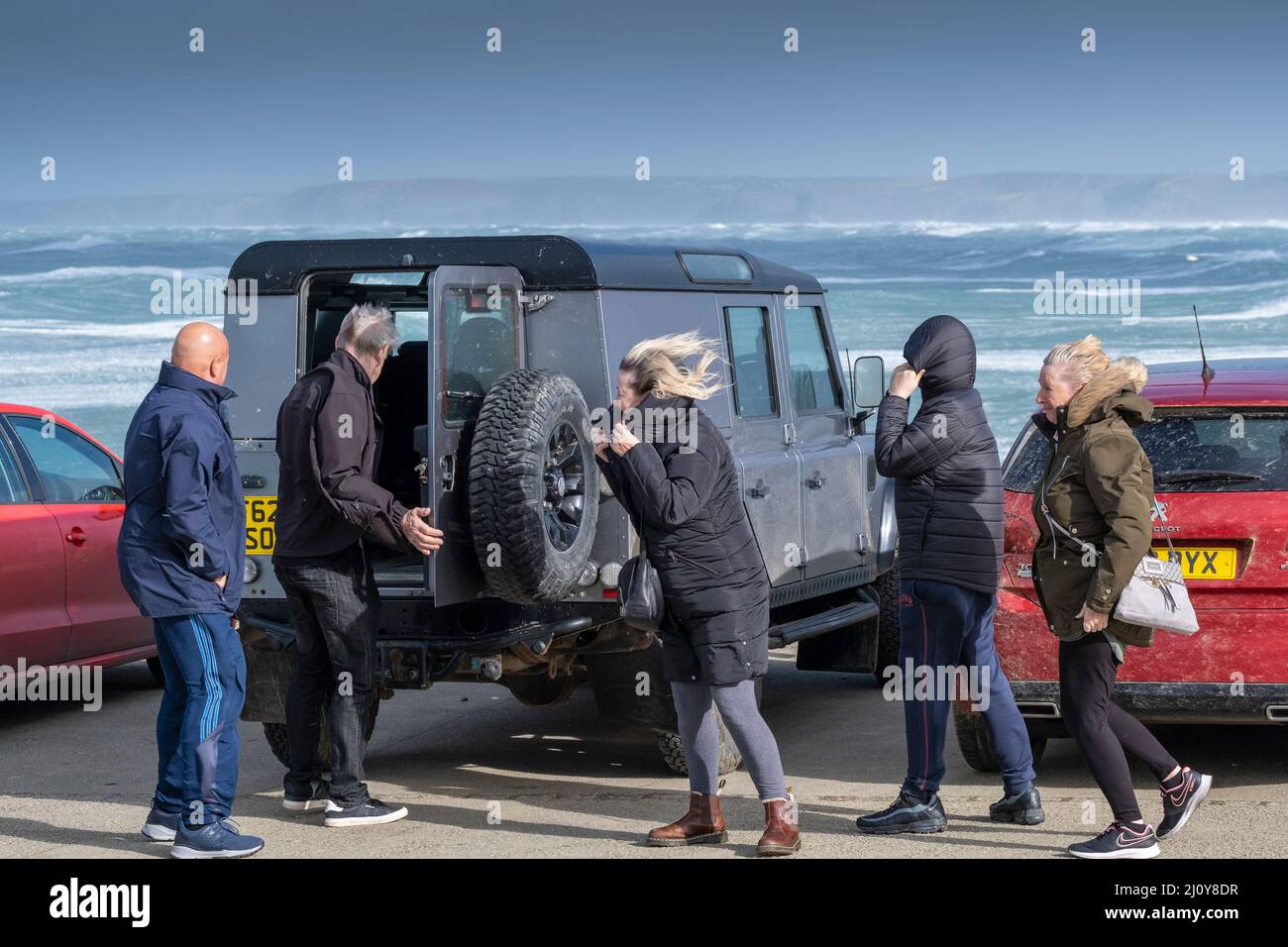 People in a car park in storm force wind brought by Storm Eunice as it ...