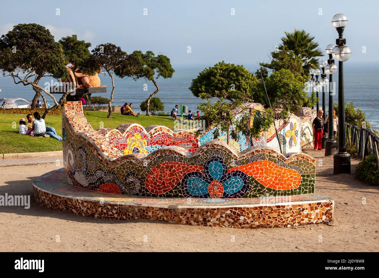 Colorful mosaic wall and people relaxing on grass in Park of Love ...