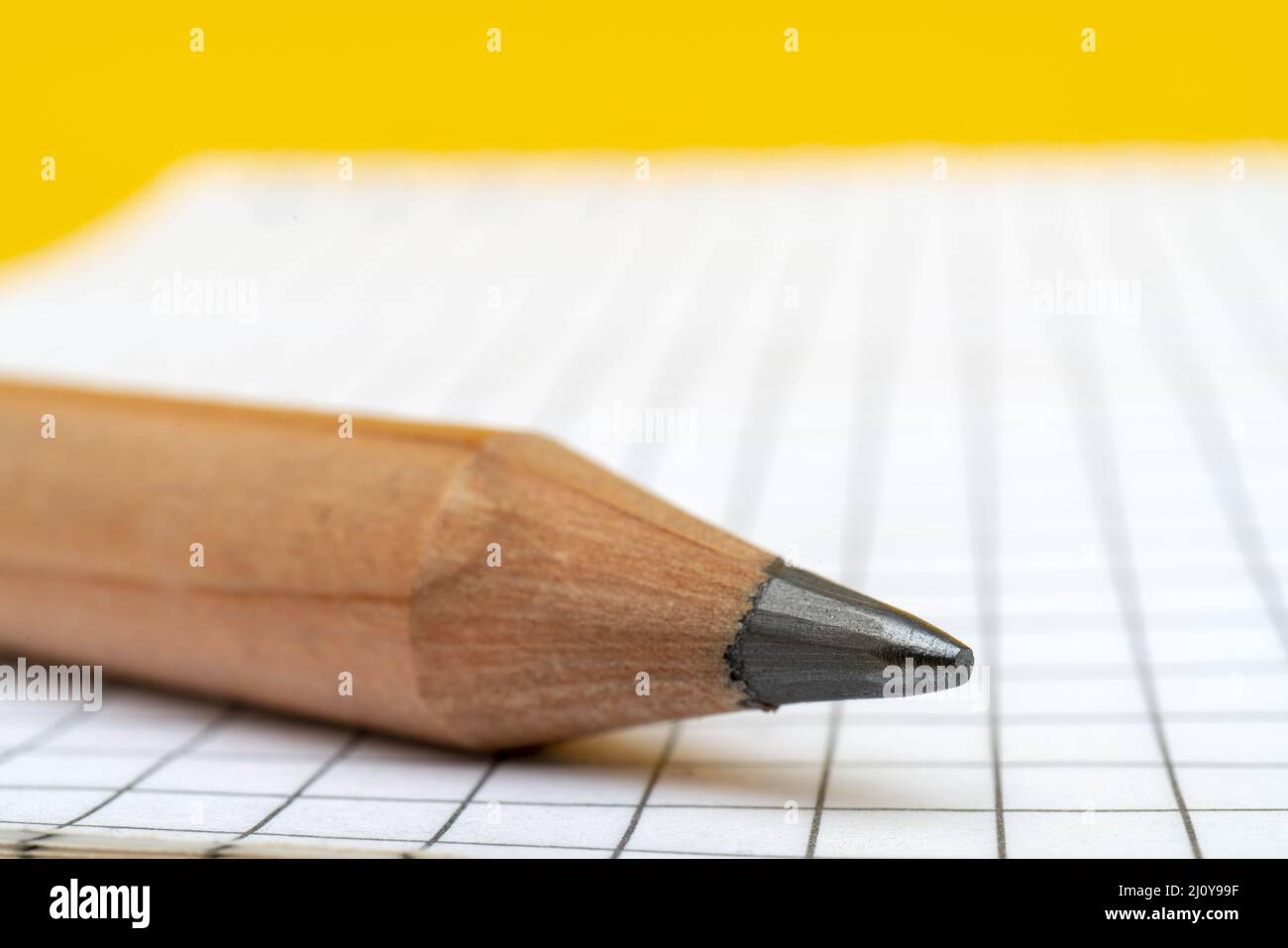 Huge pencil and checkered notepad page Stock Photo - Alamy