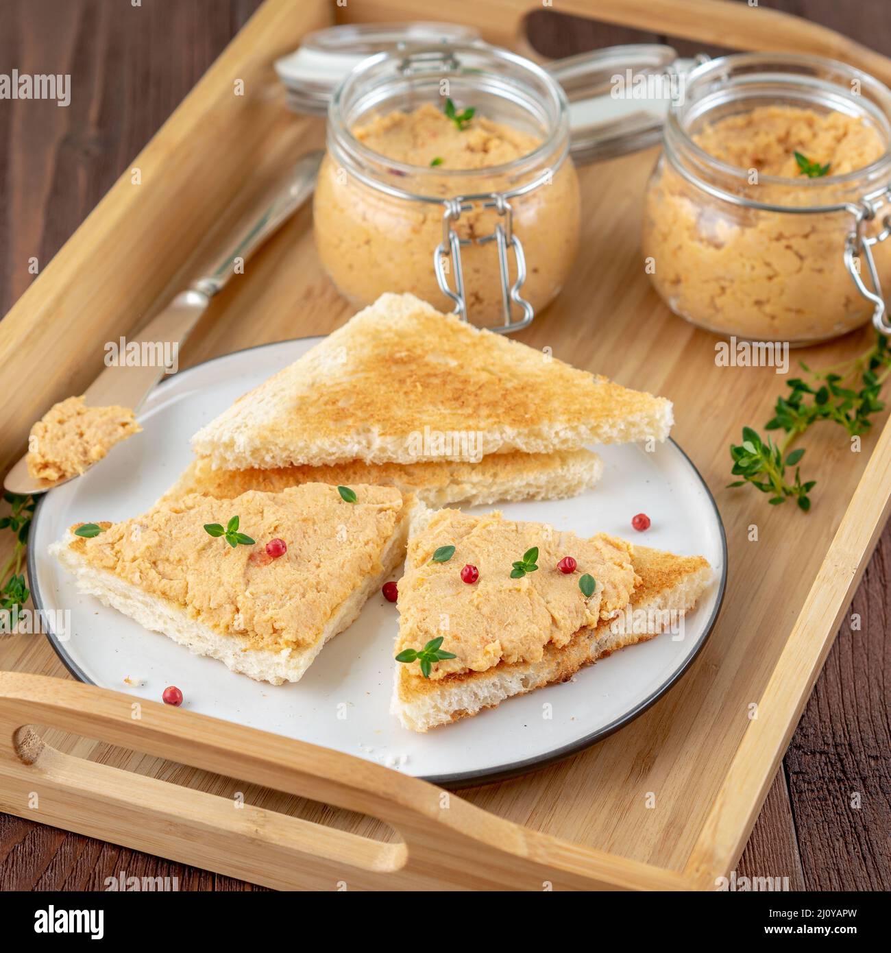 Fresh homemade chicken pate on toasted bread on tray over rustic ...