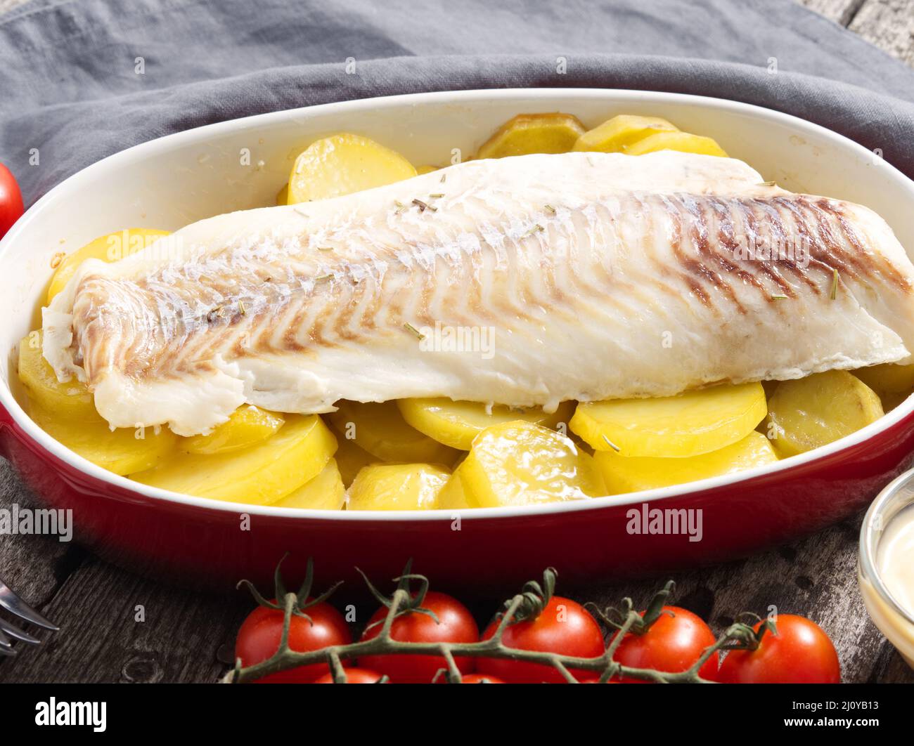 Fish cod baked in the oven with potatoes, diet healthy food. Dark old ...