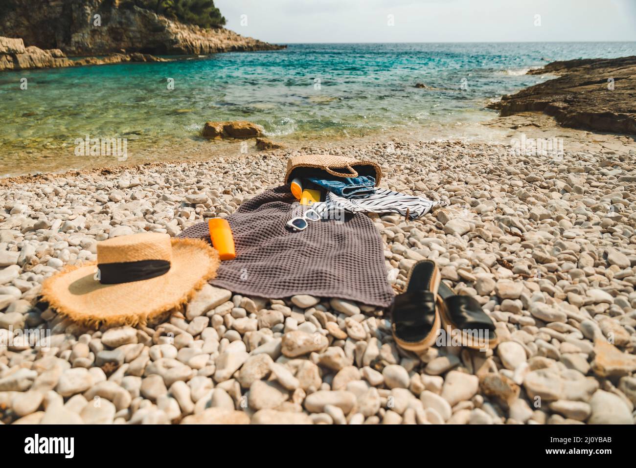 overhead view of beach stuff blanket with sun protection cream straw ...