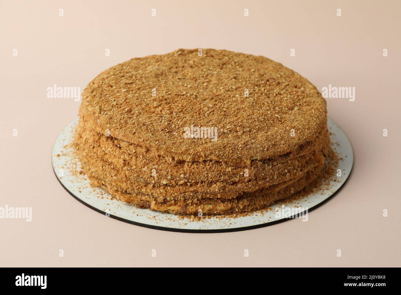 Round tasty honey cake on beige background Stock Photo - Alamy