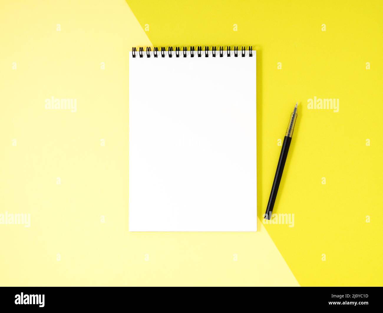 Blank notepad white page on yellow desk, color background. Top view ...