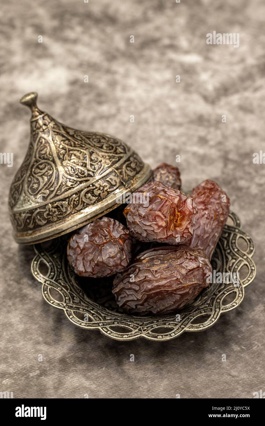 Date fruit on a dark background. Date fruits on a rustic serving plate ...