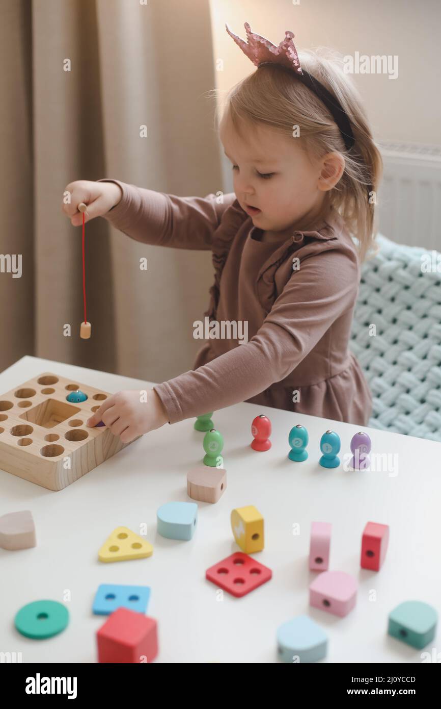 child playing and building with colorful wooden toys. Early learning ...