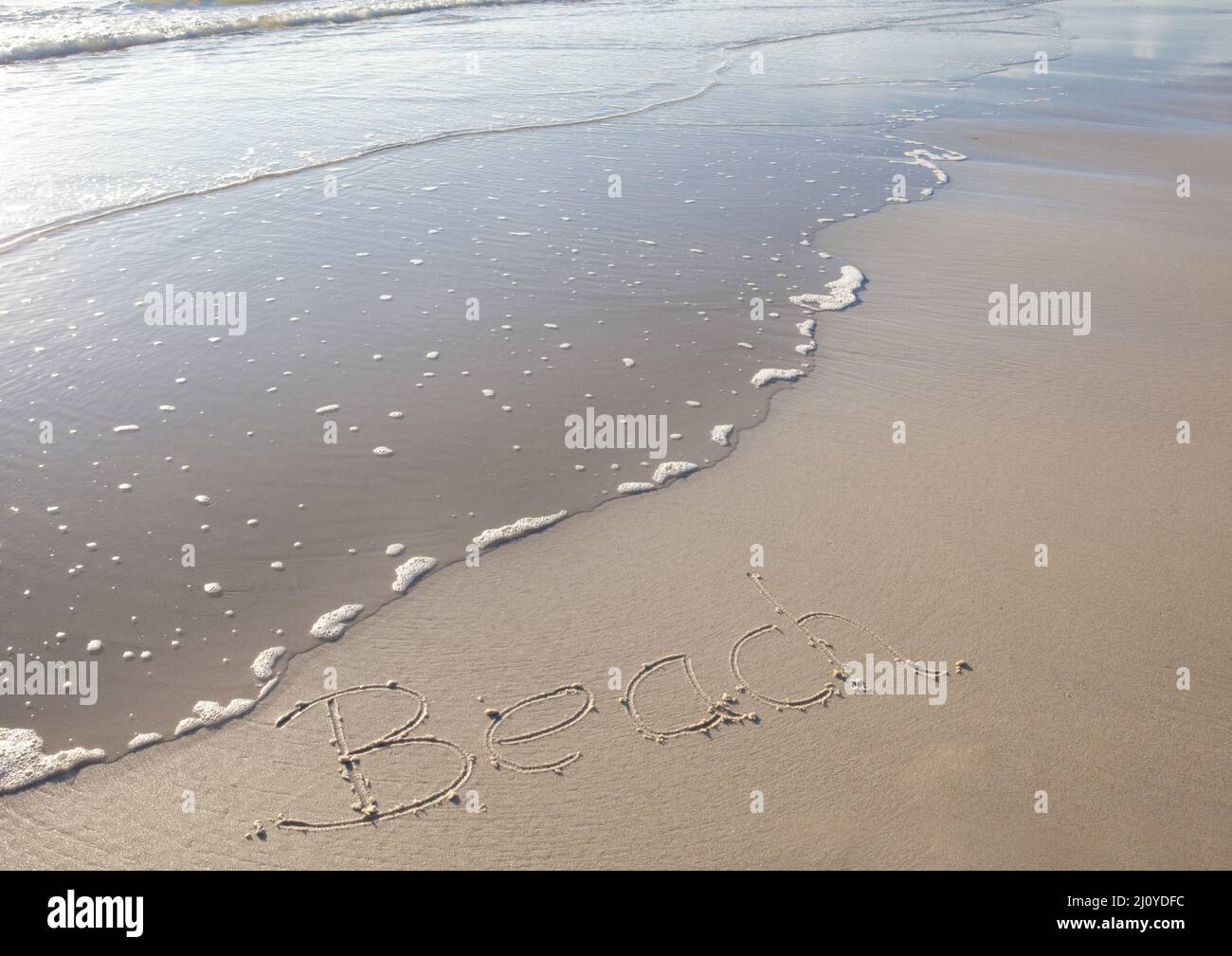 Word "beach" written in sand Stock Photo - Alamy