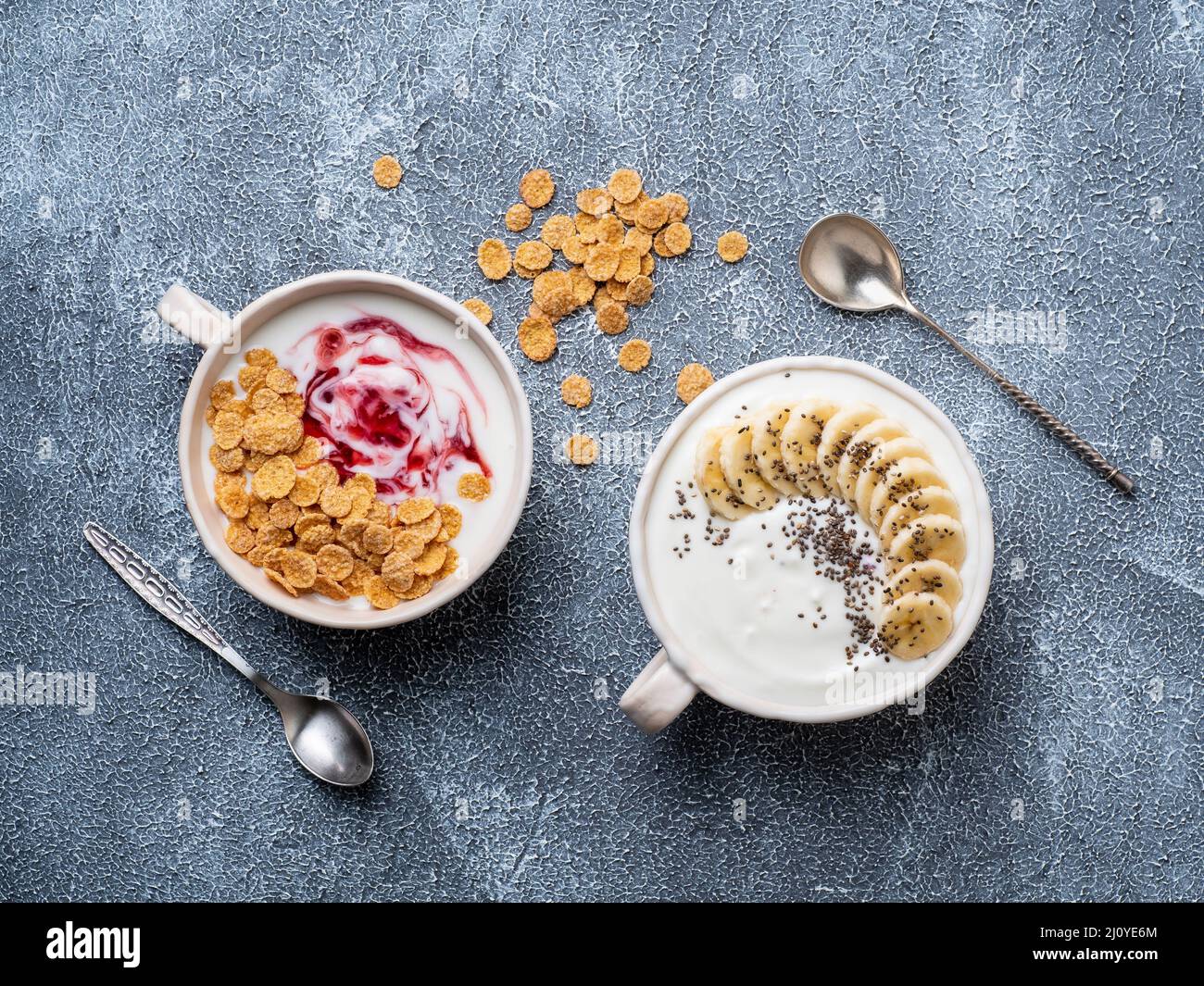 Greek yogurt with jam in white bowl on grey blue concrete stone table ...