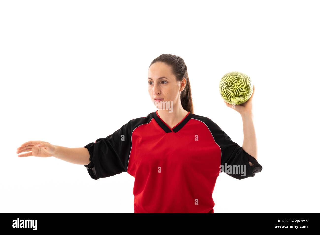 Caucasian young female handball player throwing yellow ball against ...