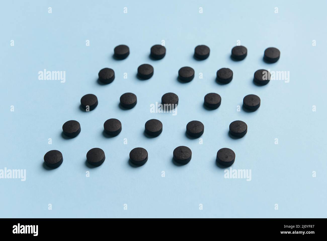 Activated carbon pills on blue background Stock Photo - Alamy
