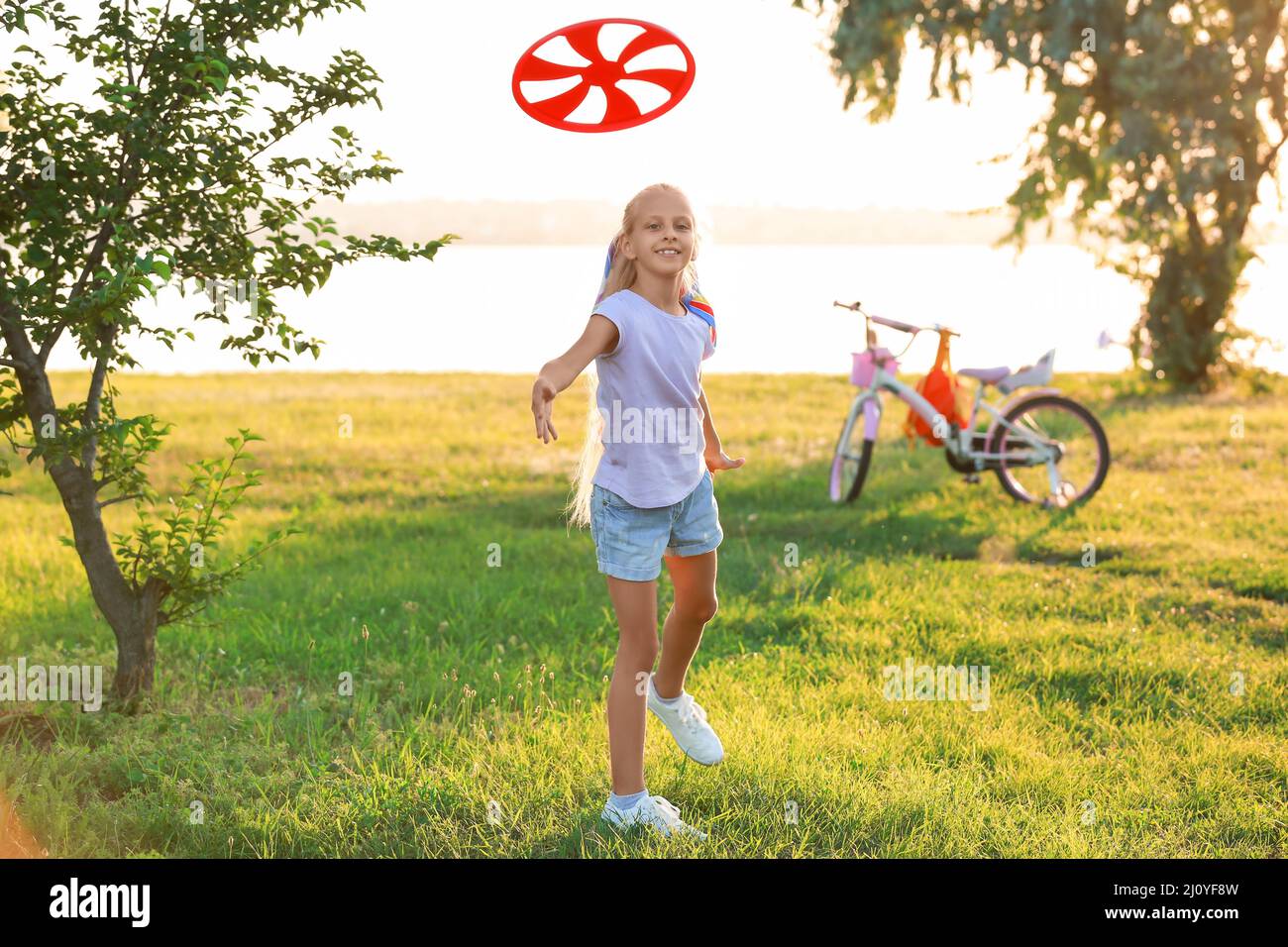 Funny little girl playing frisbee outdoors Stock Photo - Alamy