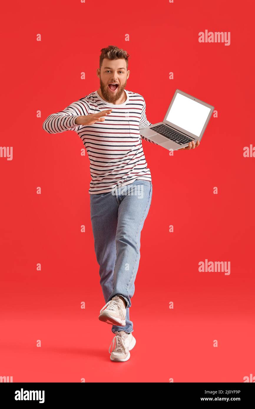 Cool dancing young man with laptop on color background Stock Photo - Alamy