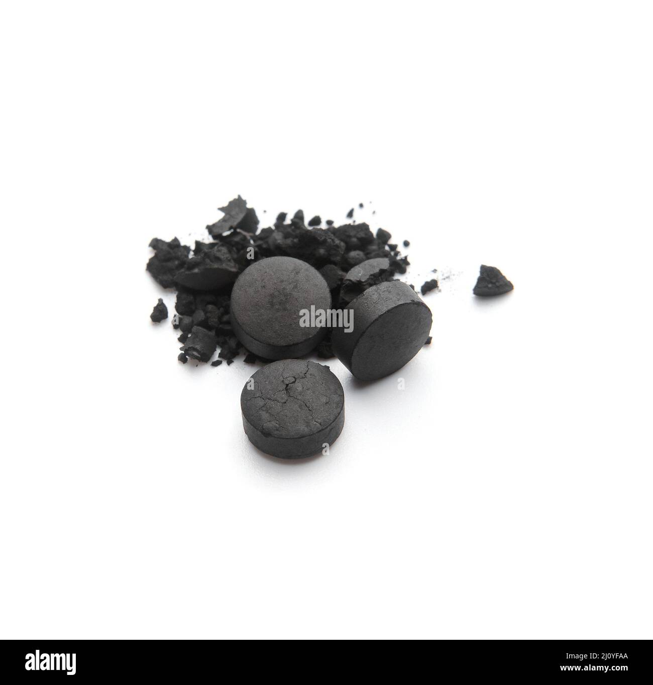 Crushed and whole activated carbon pills on white background Stock ...