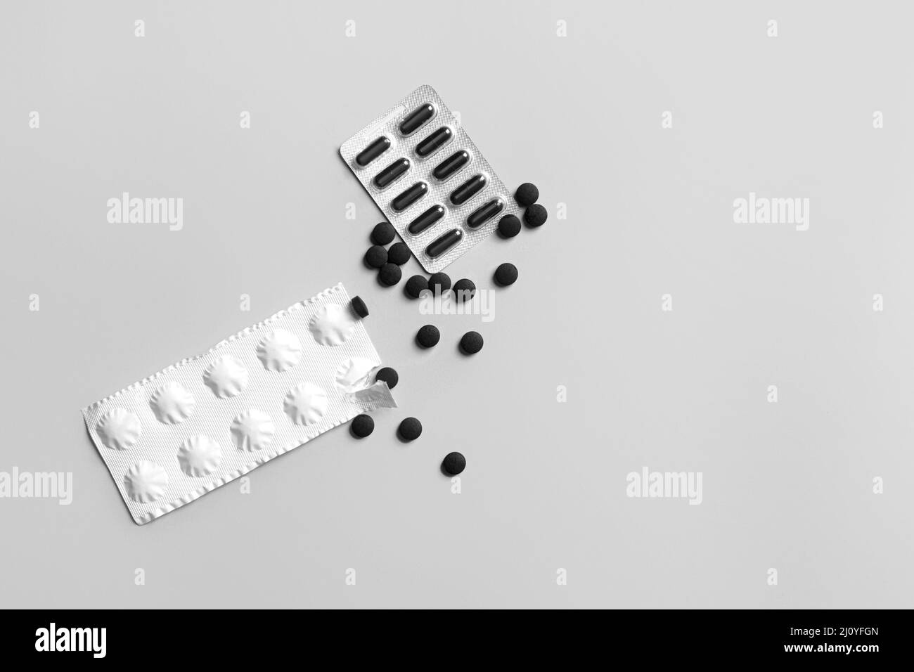 Activated carbon capsules and pills on light background Stock Photo - Alamy