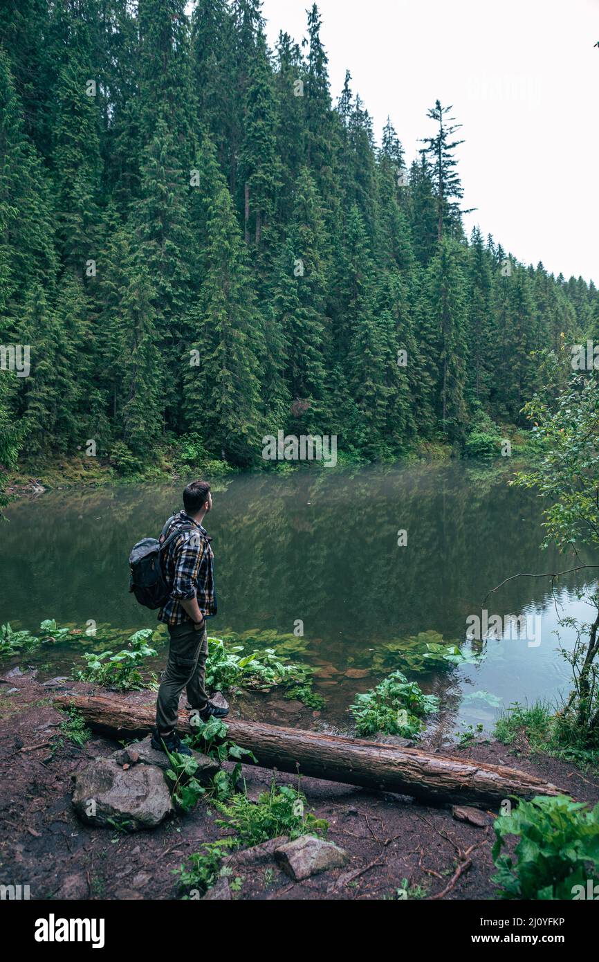 strong man hiker looking at mountain lake Stock Photo - Alamy