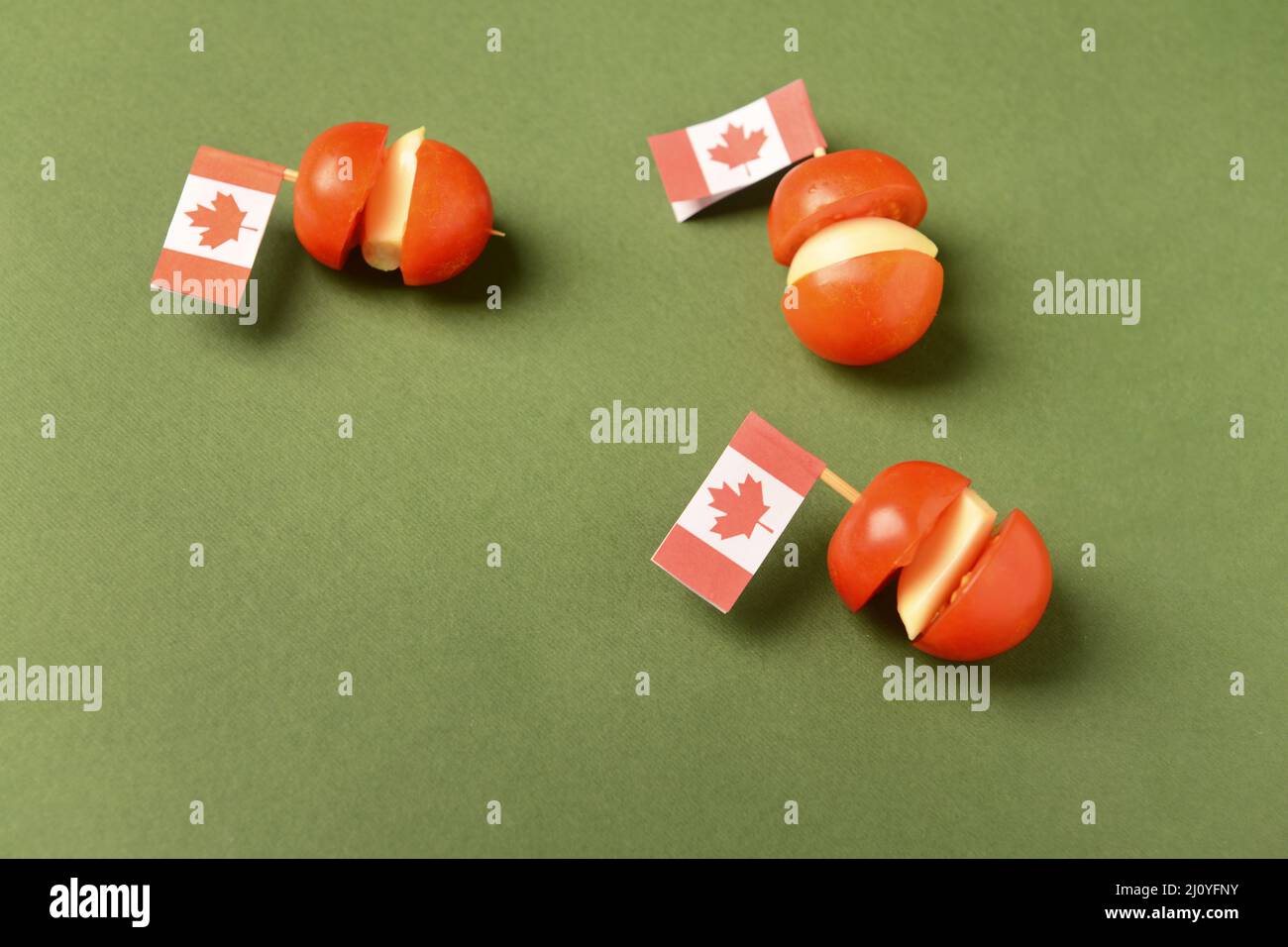 Tasty canapes with flags of Canada on green background Stock Photo - Alamy