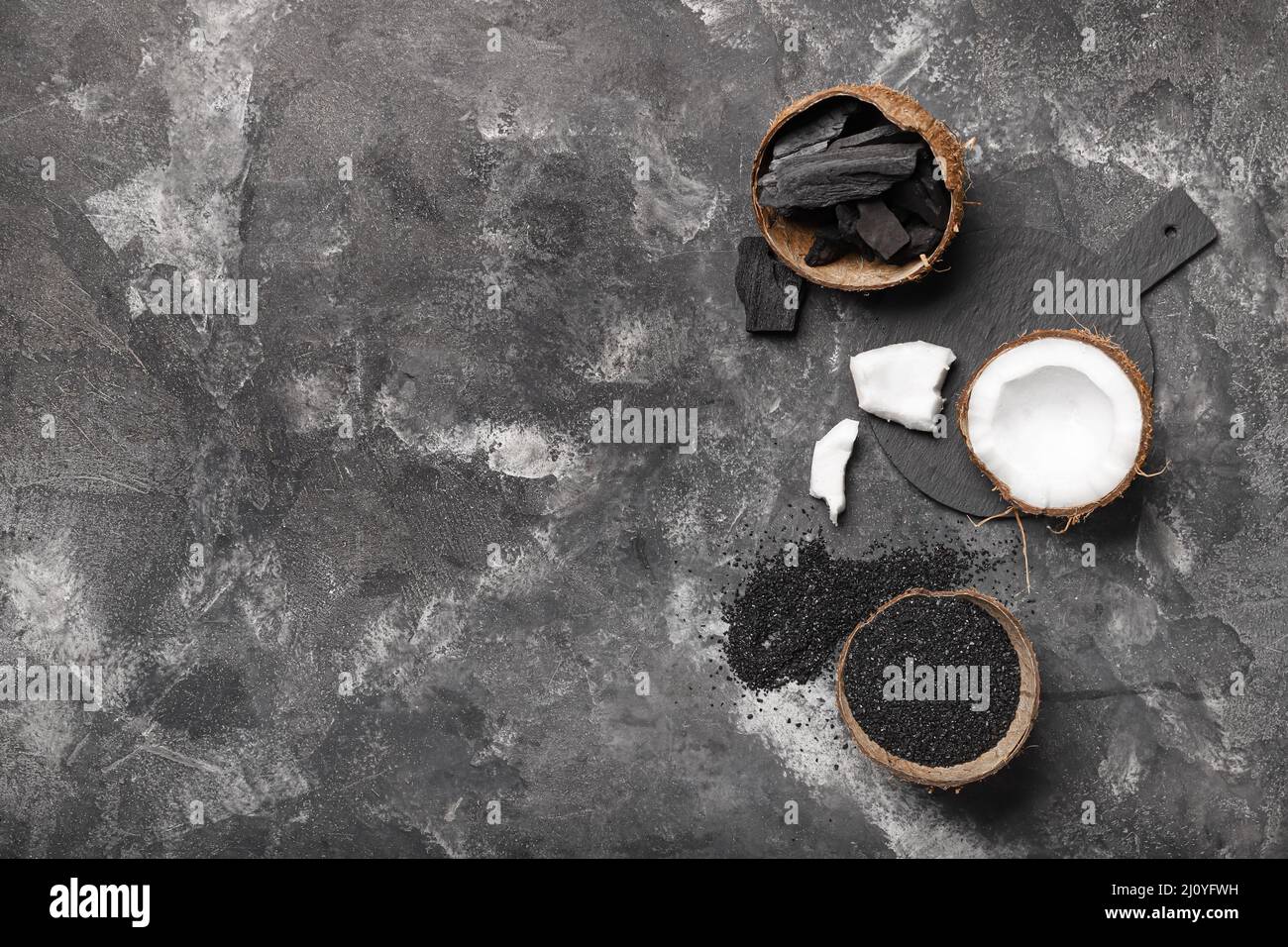 Coconut shells with activated carbon on black background Stock Photo ...