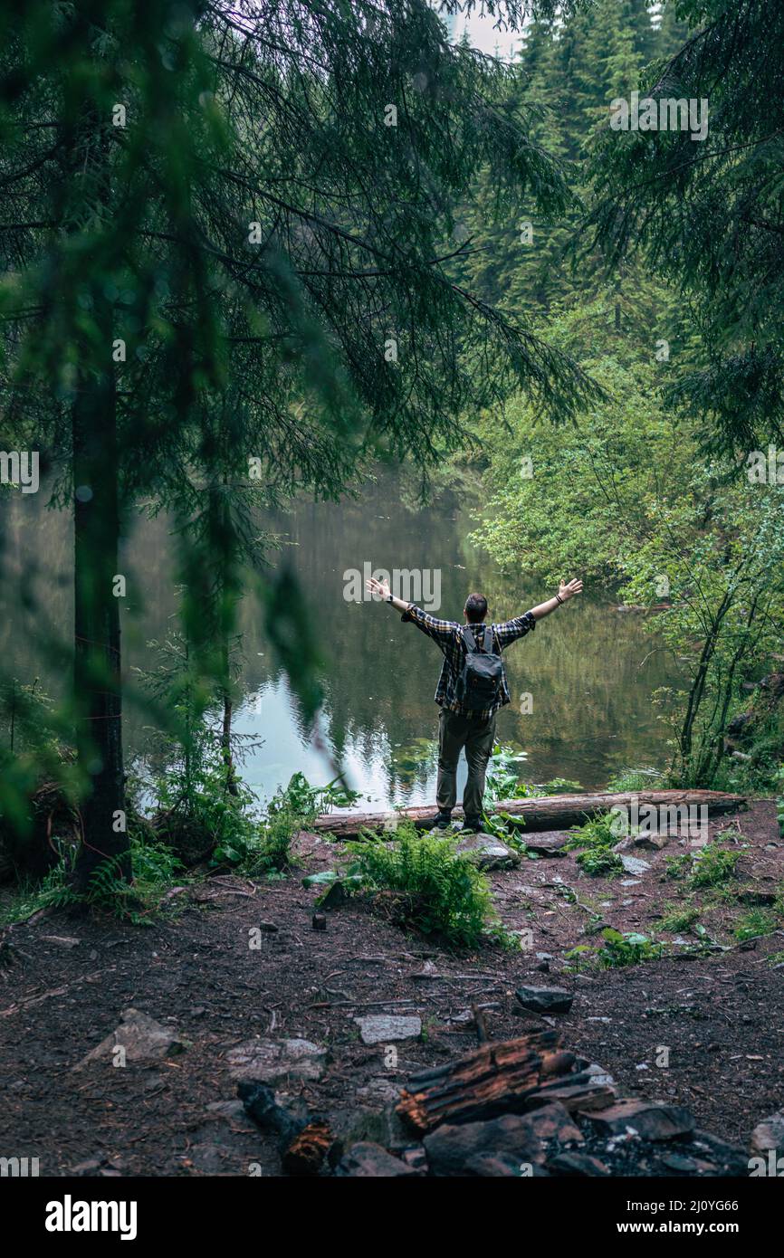 strong man hiker looking at mountain lake Stock Photo - Alamy