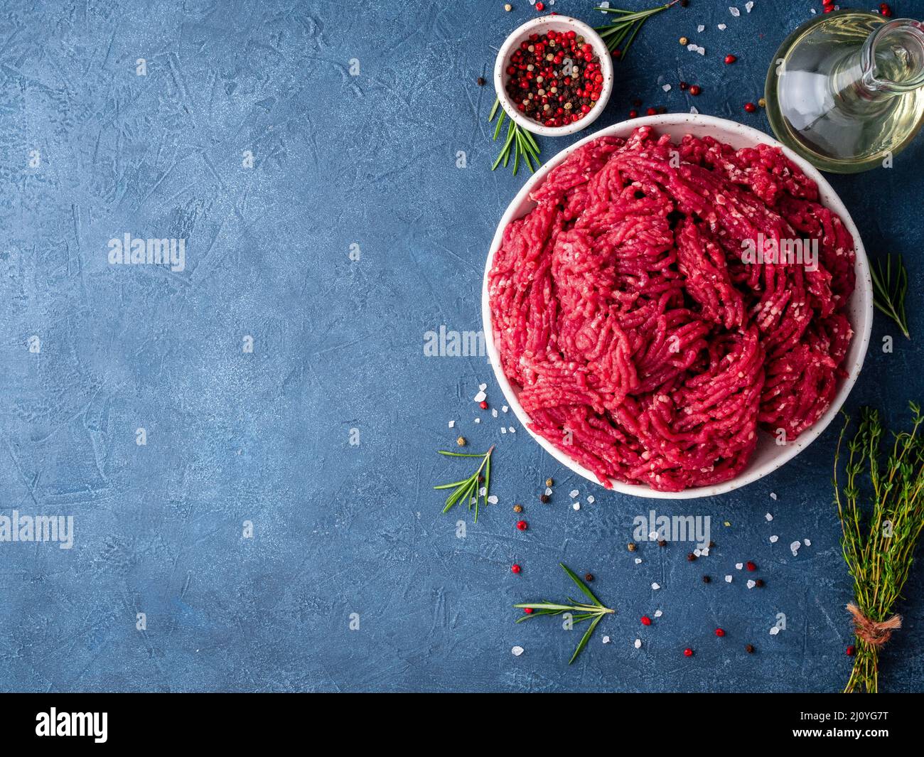 Mince beef, ground meat with ingredients for cooking on dark blue Stock ...