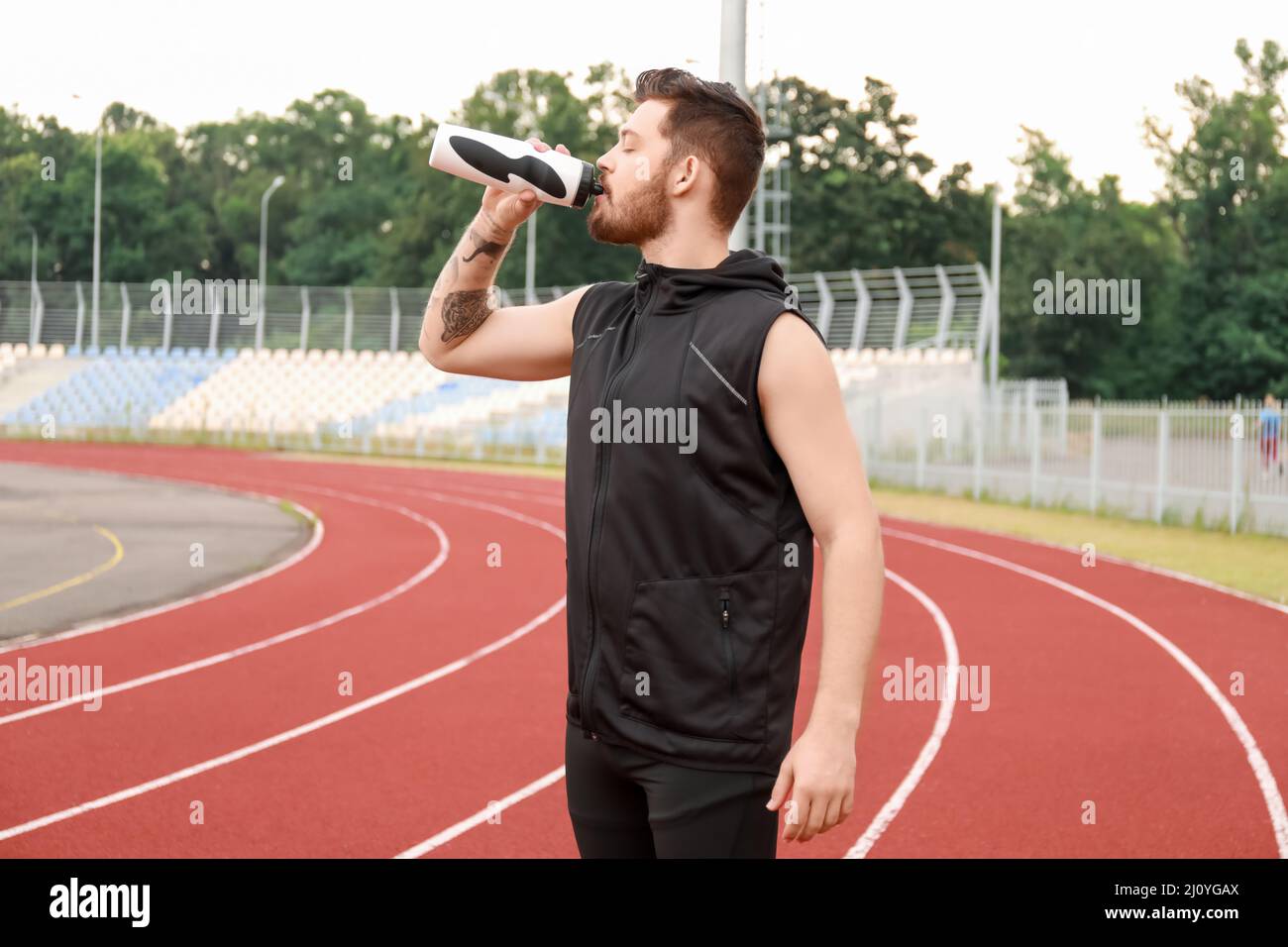 Handsome male jogger drinking water hi-res stock photography and images ...