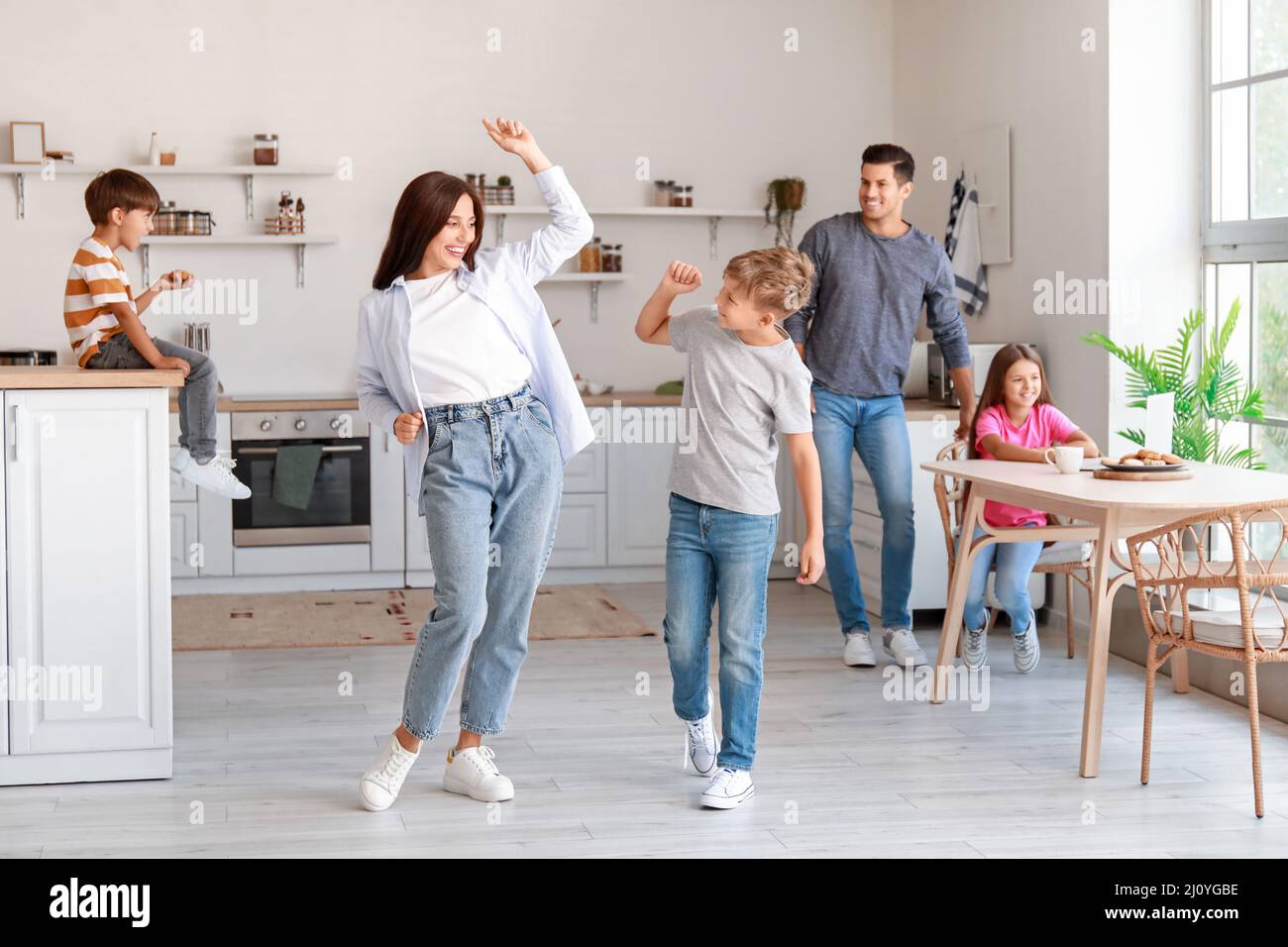 Happy family dancing in kitchen Stock Photo - Alamy