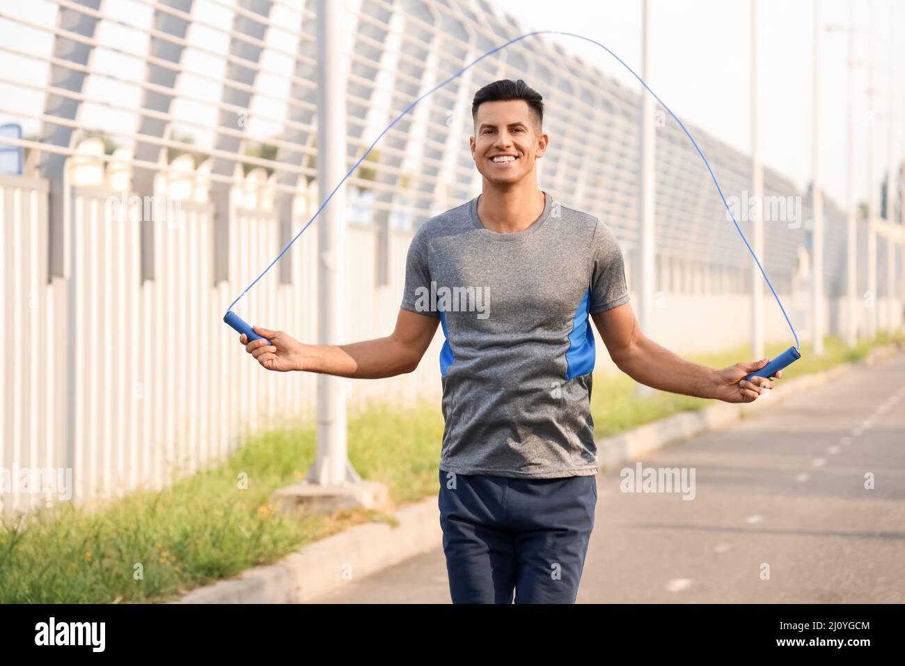Sporty young man jumping rope outdoors Stock Photo - Alamy