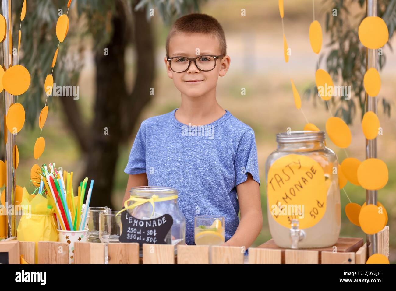 Cute boy selling lemonade in park Stock Photo - Alamy