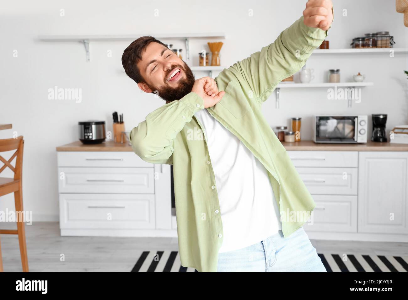 Handsome man dancing in kitchen Stock Photo - Alamy