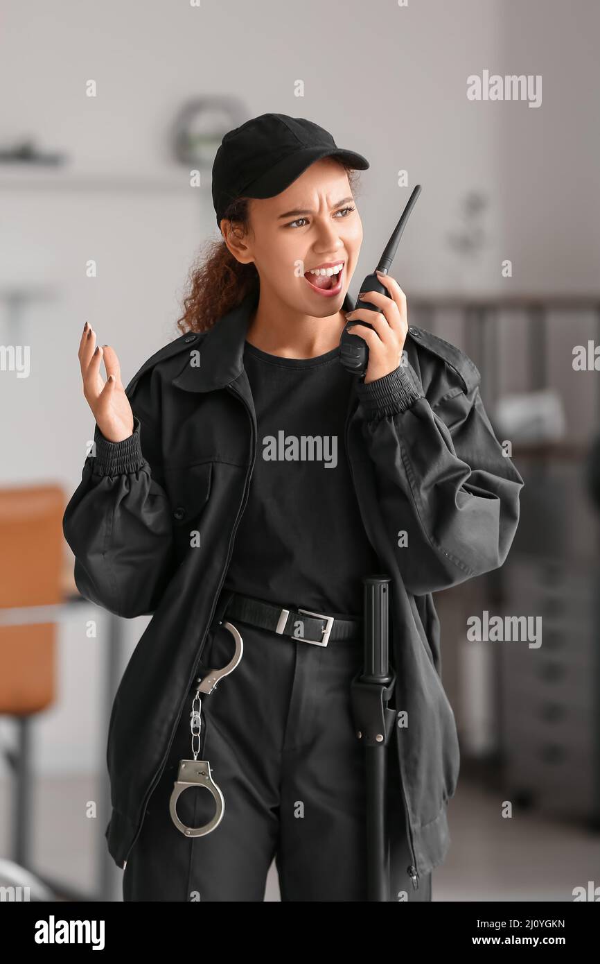 Angry African-American female security guard with radio transmitter in ...