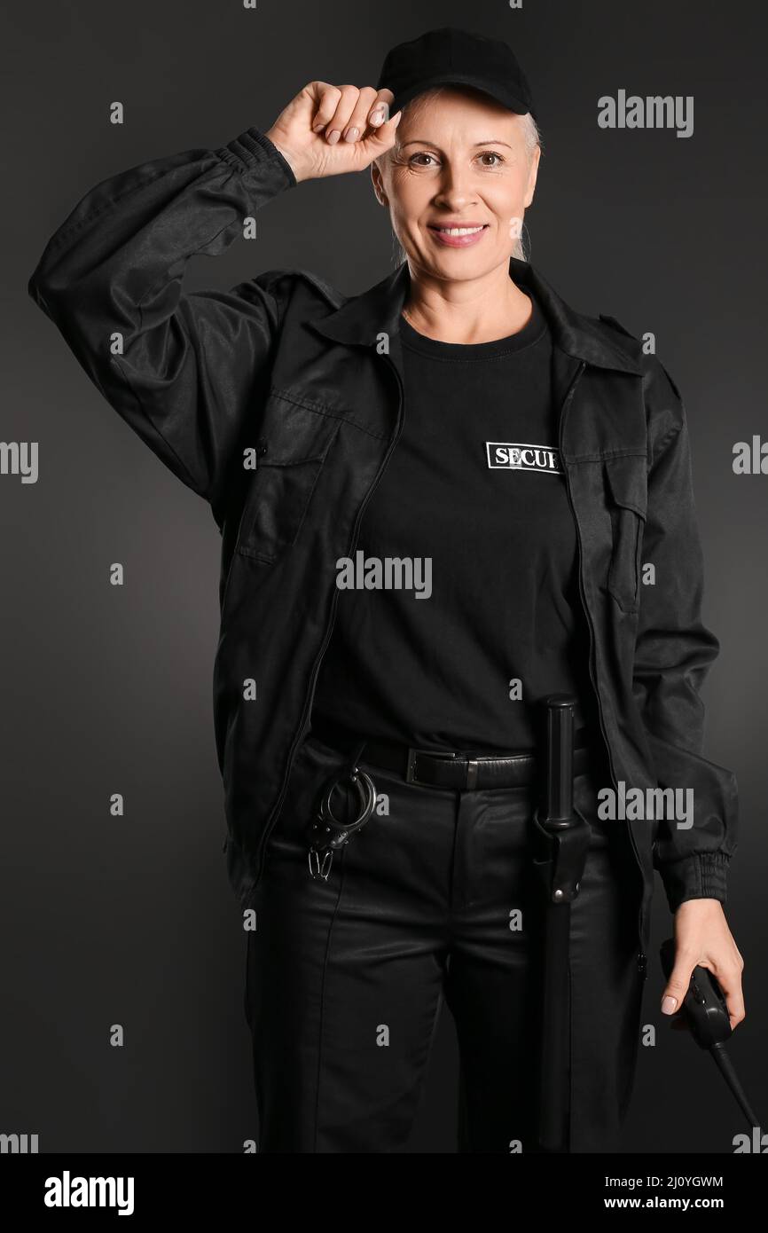 Female security guard on dark background Stock Photo - Alamy