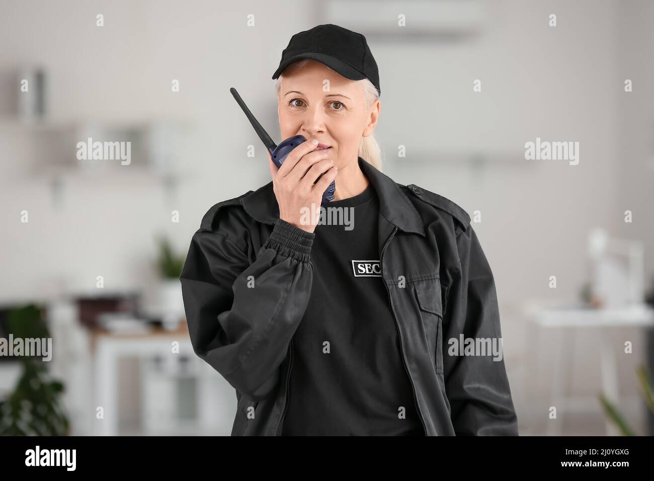 Female security guard with radio transmitter in office Stock Photo - Alamy