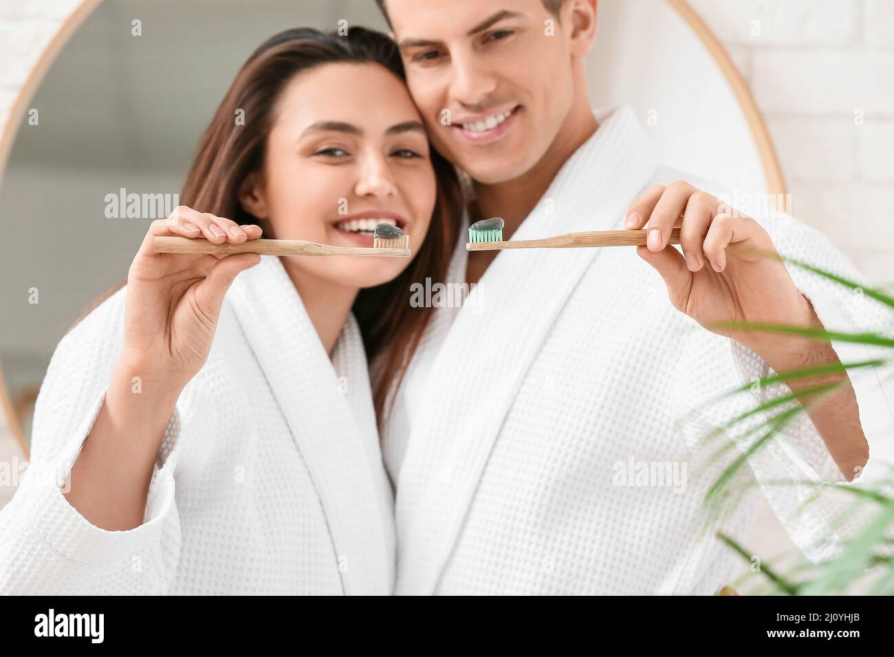 Young couple brushing teeth with activated charcoal tooth paste in ...