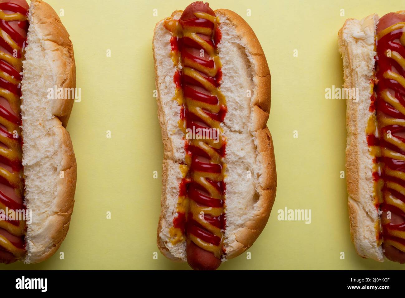 Directly above close-up shot of sauces on hot dogs arranged side by ...