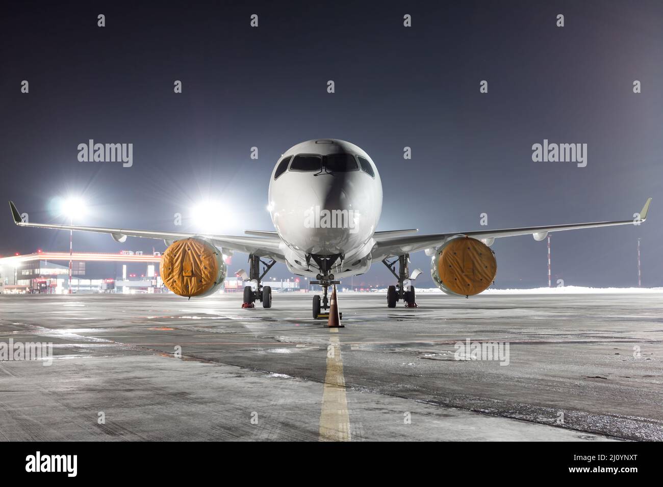 Front view of the modern passenger jet plane on the night airport apron ...