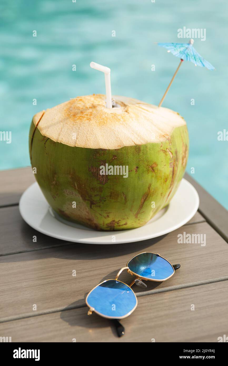 Fresh coconut drink and sunglasses on the table Stock Photo - Alamy