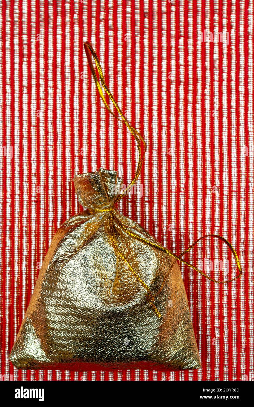 Shiny golden pouch on a red background. A gift on a holiday Stock Photo ...
